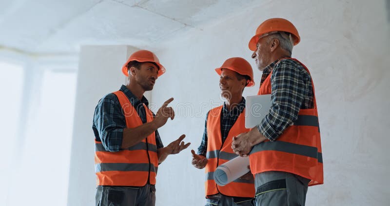 Builder Gesturing while Talking with Coworkers Stock Image - Image of ...