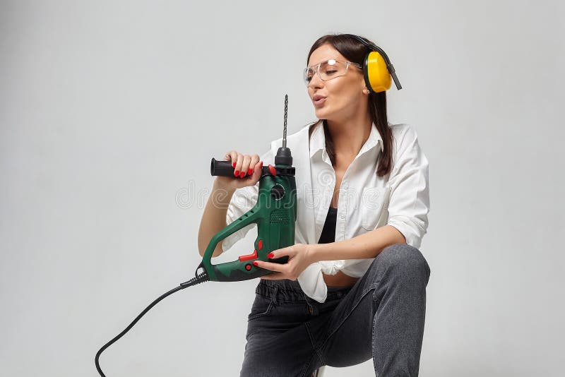 Builder Girl Holding a Drill. Concept of Housewives, Working Tools and ...