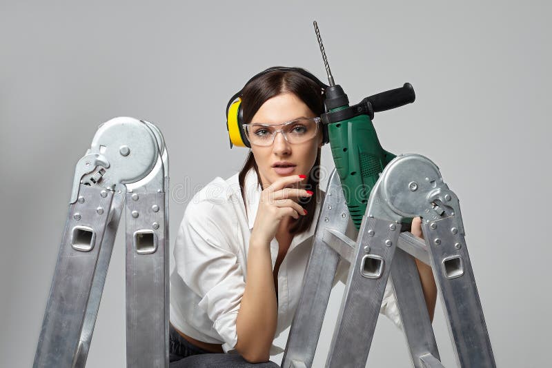Builder Girl Holding a Drill. Concept of Housewives, Working Tools and ...