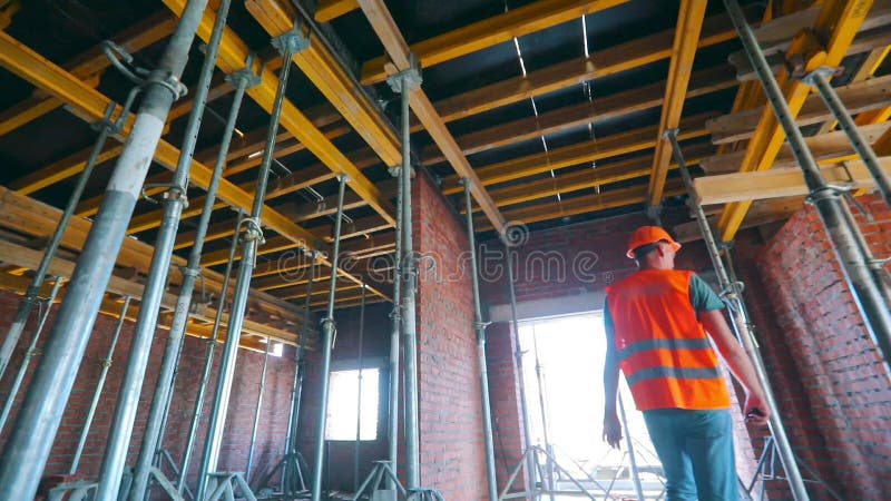 The Builder Goes Inside the Building Under Construction. Builder Inside ...