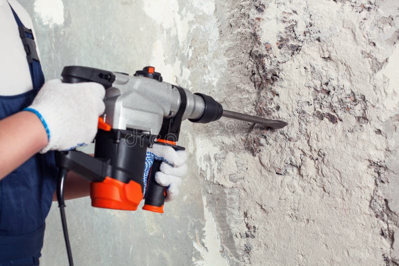 The Builder with Hammer Drill Perforator Equipment Making Hole in Wall ...