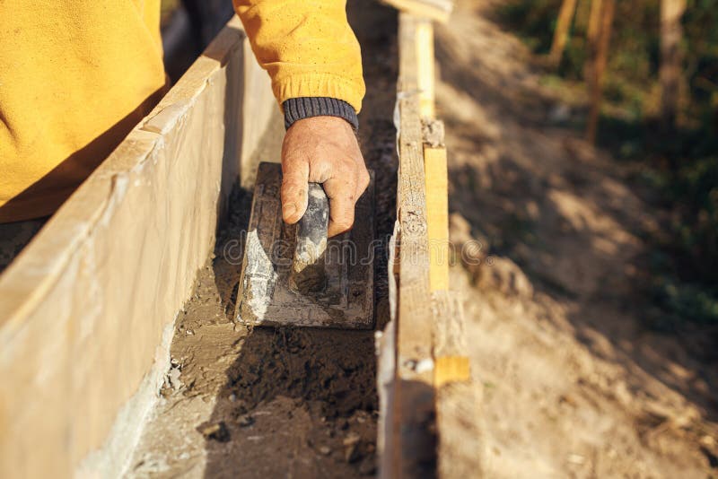 Builder Hand with Trowel Working with Concrete in Wooden Formwork with ...