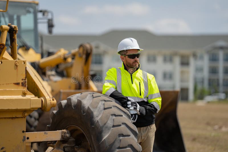 Builder in Helmet with Excavator for Construction at the Construction ...
