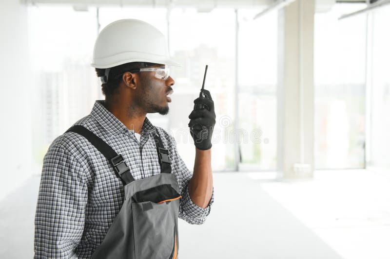 Builder in Helmet is Standing in Front of the Construction Site ...