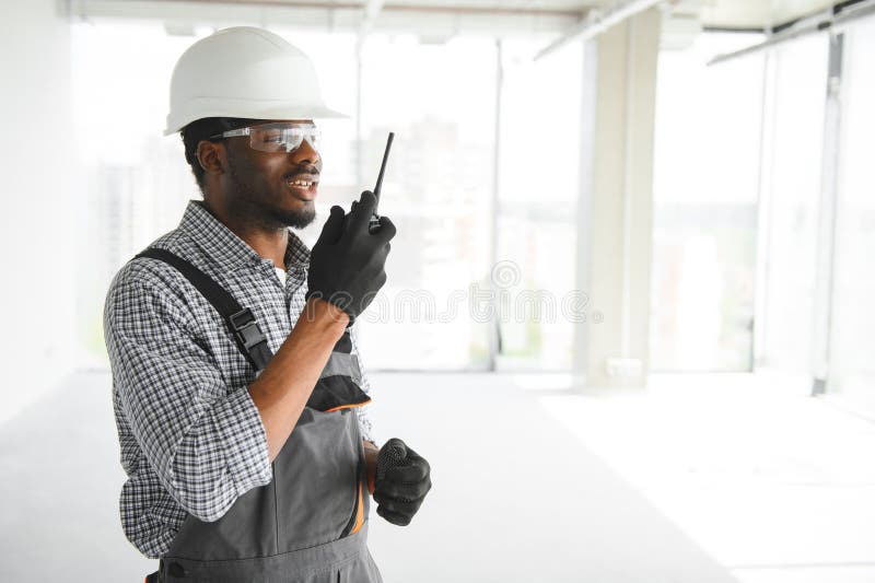 Builder in Helmet is Standing in Front of the Construction Site ...