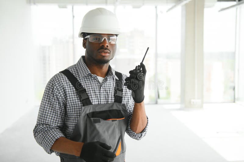Builder in Helmet is Standing in Front of the Construction Site ...