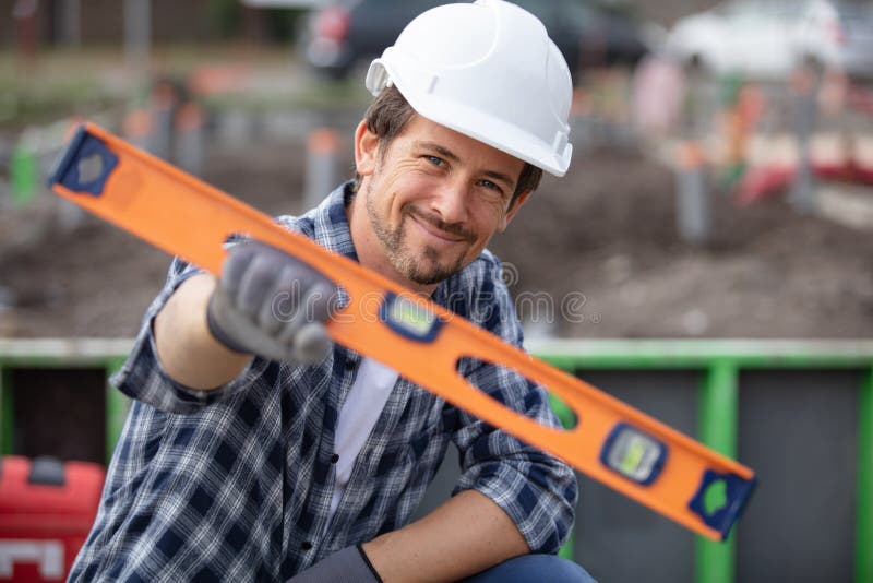 Builder Holding Spirit Level at Construction Site Stock Photo - Image ...