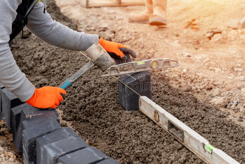 Builder Installing Paving Blocks during Road and Footpath Construction ...