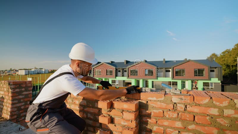 Builder Laying Bricks at a Construction Site. Builder Laying Bricks and ...