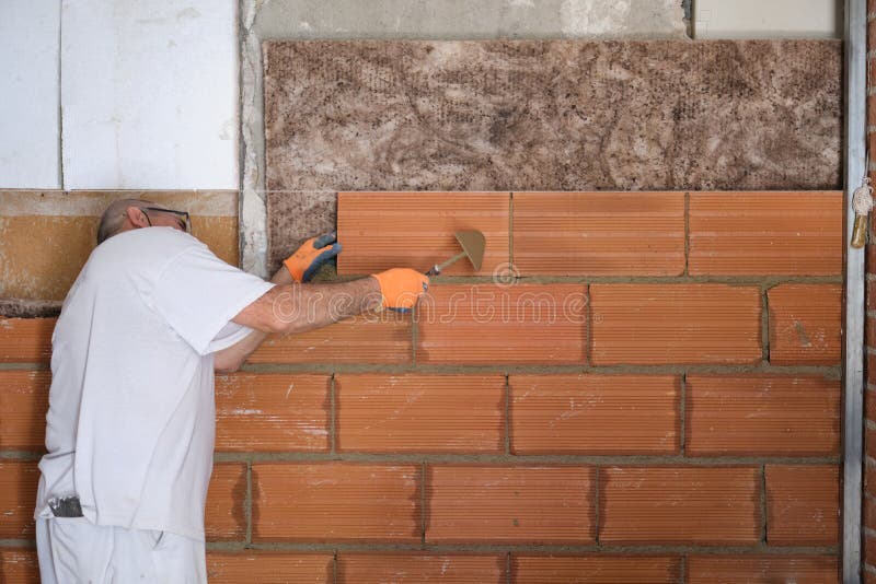 Builder Laying Bricks after Placing an Acoustic and Thermal Insulation ...