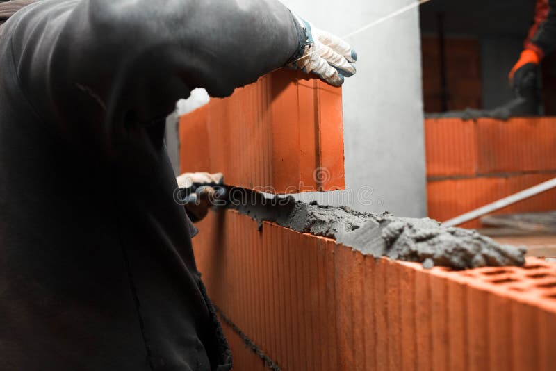Builder Laying a Large Brick Block on the Mortar Creating a Wall Stock ...