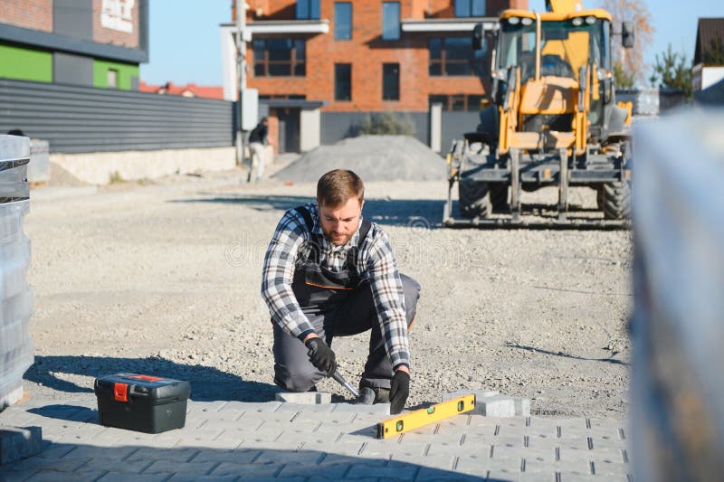Builder Laying a Paving Brick Placing it on the Sand Foundation with ...