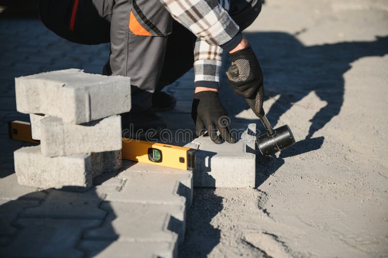 Builder Laying a Paving Brick Placing it on the Sand Foundation with ...