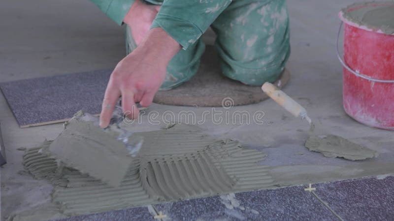 The Builder Lays Tiles on the Cement Mortar. Construction Worker Laying ...