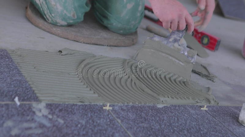 Construction Worker Laying Tiles on the Floor for Mortar. the Builder ...