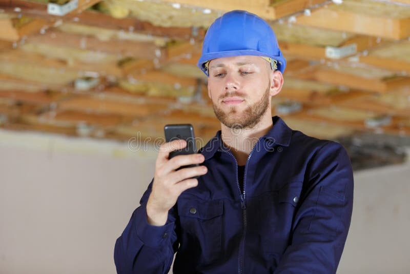 Builder man checking phone stock image. Image of professional - 208759739