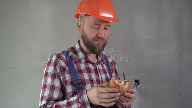 Builder Man Eating Hamburger in a Break on Workplace Stock Footage ...