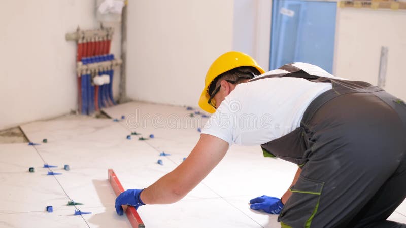 A Builder Measures the Level of the Floor. a Worker during the Laying ...