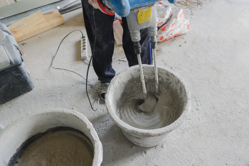The Builder Mixes the Construction Mixture in a Container for Guiding ...