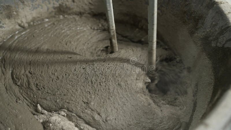 A Builder Mixes Mortar in a Bucket Using a Manual Concrete Mixer. the ...
