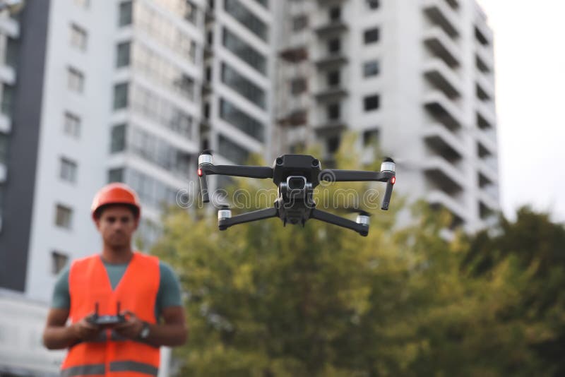 Builder Operating Drone with Remote Control at Construction Site, Focus ...