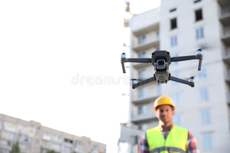 Builder Operating Drone with Remote Control at Construction Site, Focus ...