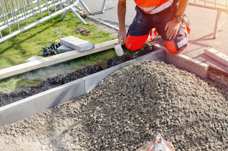 Builder in Orange Ho-viz Protective Closing Placing Edging Pin Kerb ...