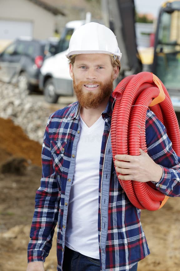 Builder Outdoors on Construction Site Holding Red Pipe Stock Photo - Image of workman, blue ...