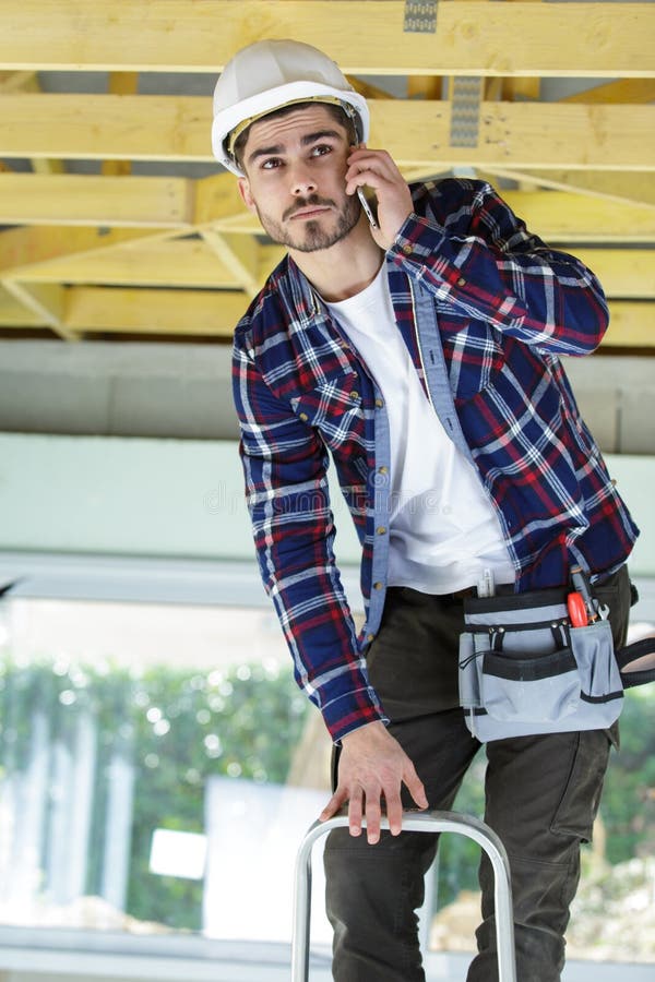 Builder on phone on ladder stock image. Image of outdoors - 164154283
