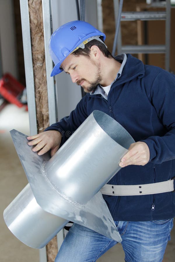 Builder with pipe indoors stock photo. Image of gloves - 261513308