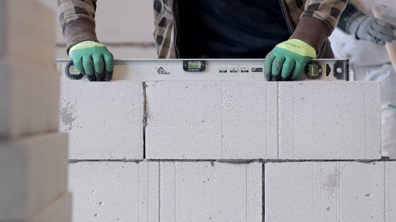The Builder Places the Block during the Construction of the Wall. Stock ...