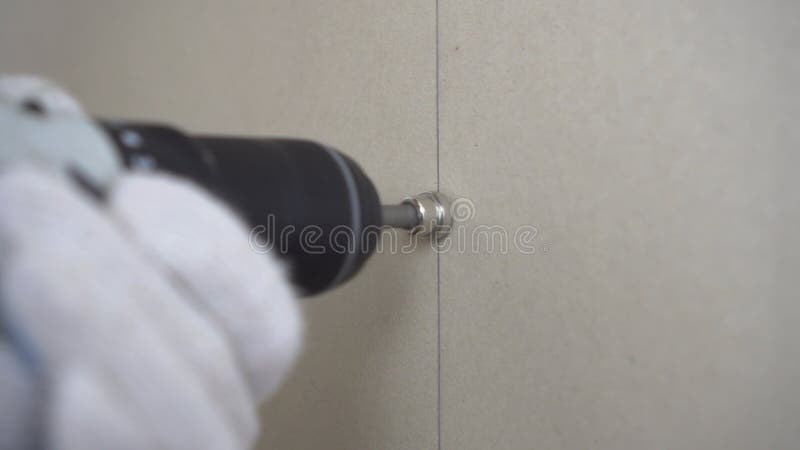 The Builder Screws the Gypsum Board with a Self-tapping Using a ...