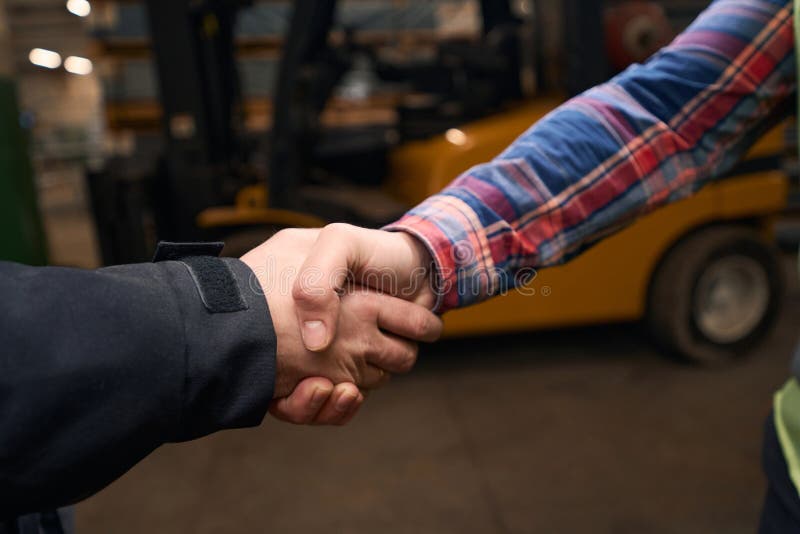 Builder Shaking Hands with Client after Successful Deal in Warehouse ...