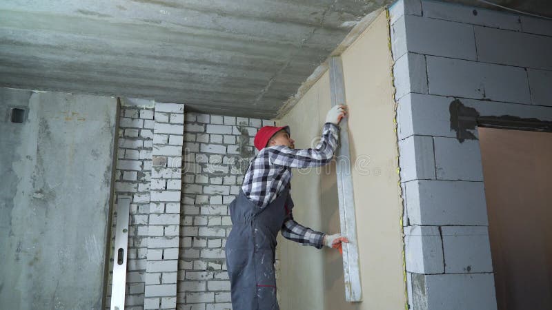 Plasterer Smoothing Plaster on Interior Wall with Construction Ruler ...
