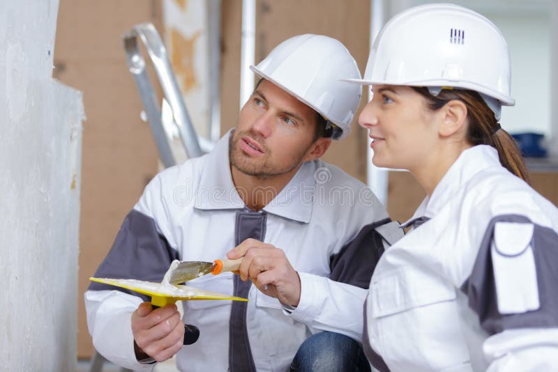 Builder with Spatula Talking To Female Colleague Stock Photo - Image of ...