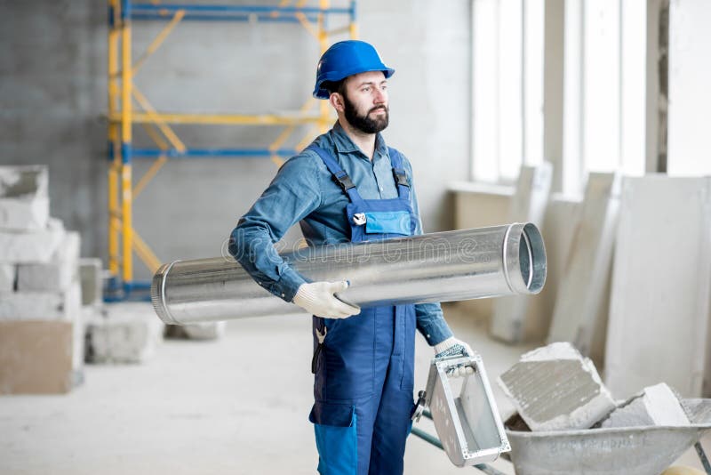 Builder with pipe indoors stock photo. Image of installation - 112961406