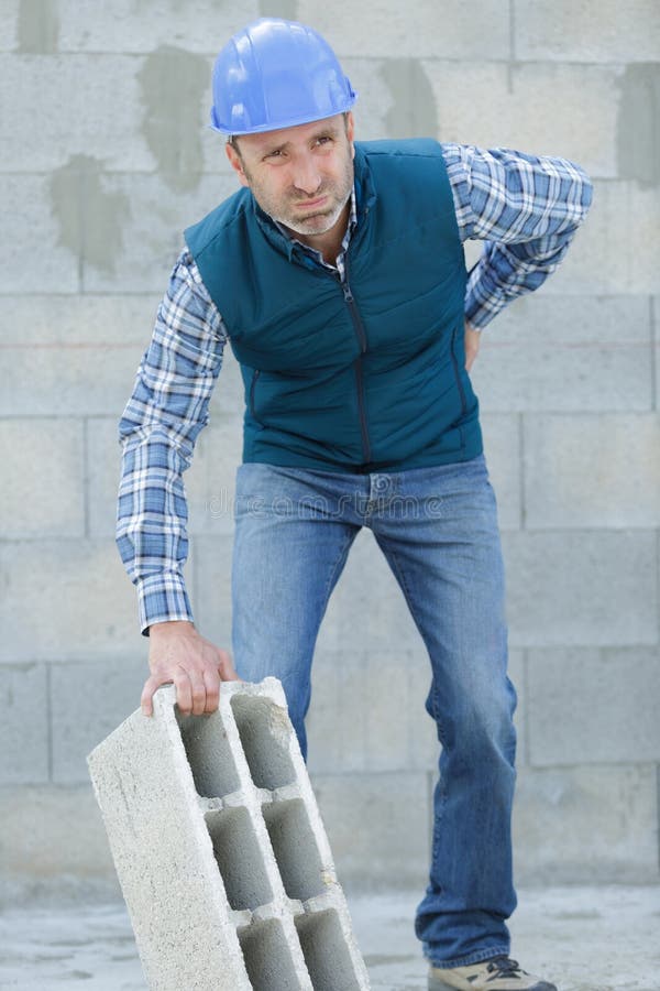 Builder Suffering from Back Pain Holding Concrete Block Stock Photo ...