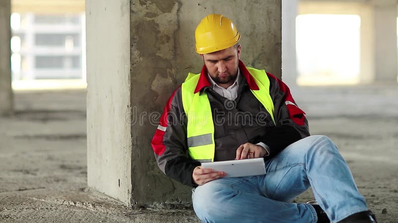 Builder with Tablet Computer Sits on the Floor Stock Video - Video of ...