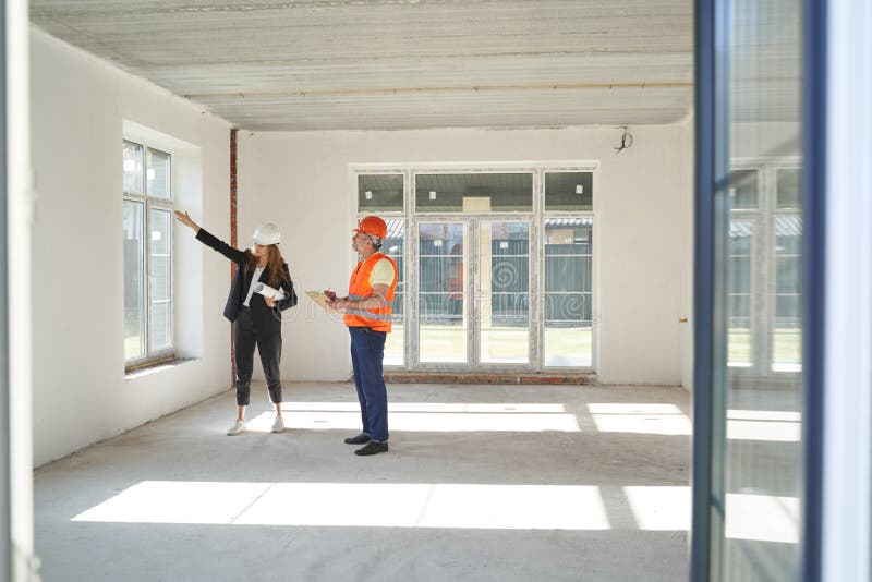 Builder Taking Notes from Female Engineer about Window Stock Photo ...