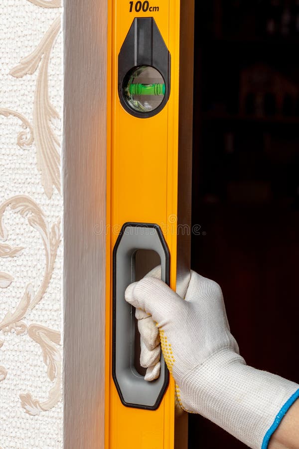 The Builder Uses a Construction Level To Check the Vertical of the Wall ...