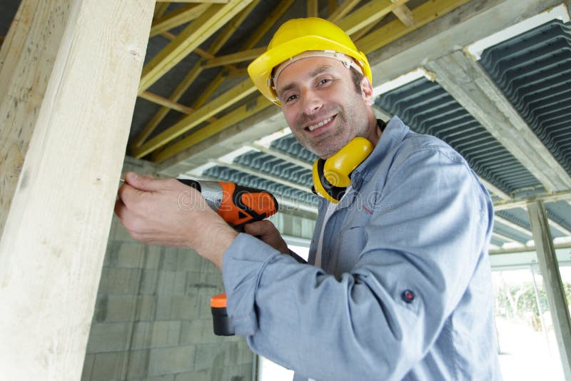 Builder Using Cordless Drill on Construction Site Stock Photo - Image ...