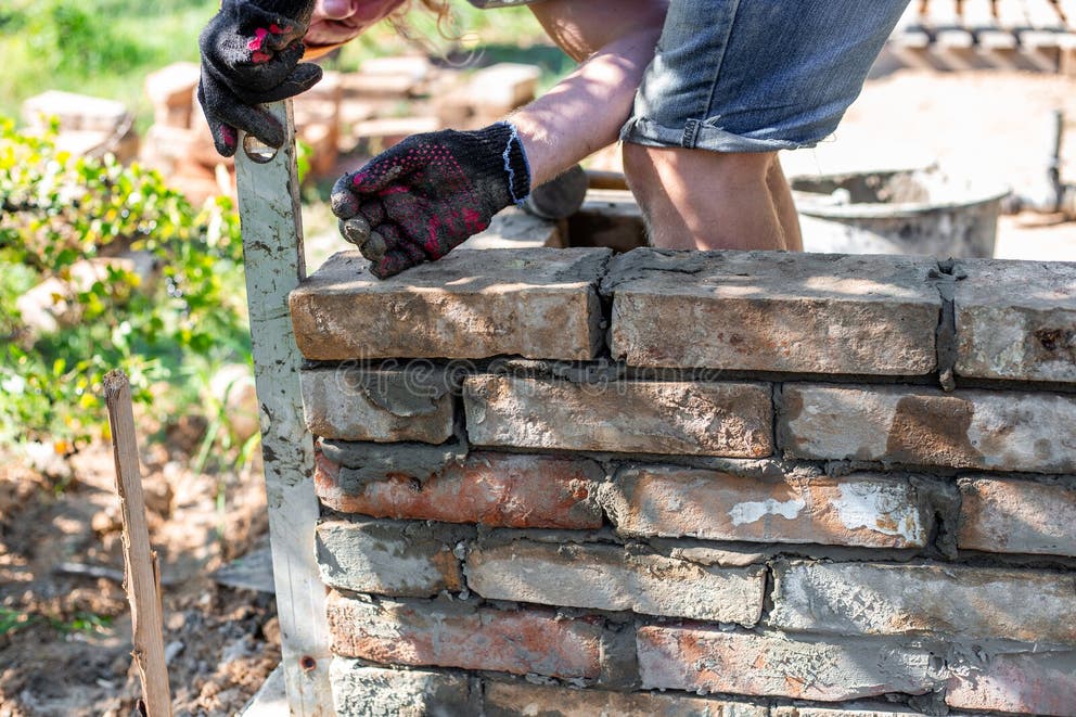 A Builder Using a Level To Ensure the Alignment and Stability of a ...
