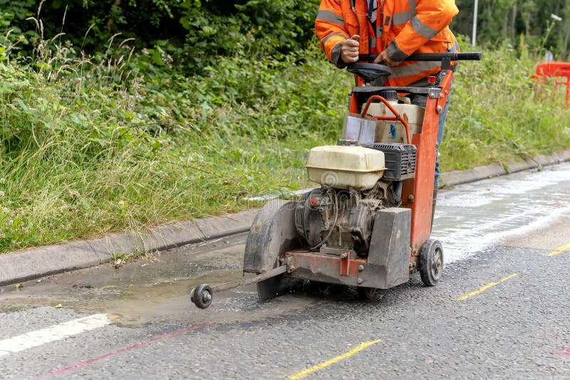 Builder Using Petrol Powered Road Saw with Dimond Blade To Cut Asphalte ...