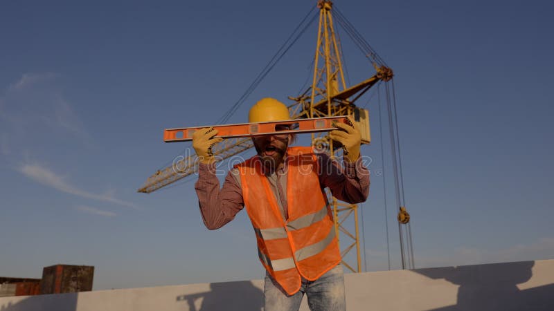 Construction Worker Using Spirit Level at Building Site with Crane in ...