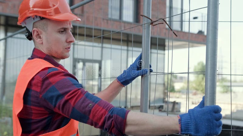 Experienced Construction Worker Fixing Chain-link Fencing on Building ...