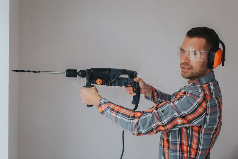 Builder Worker with Equipment Making Hole in Wall at Construction Site ...