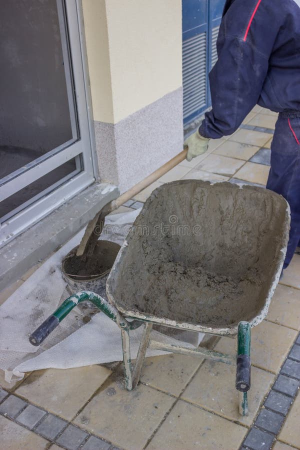 Builder Worker Putting Mortar in a Bucket 2 Stock Photo - Image of ...