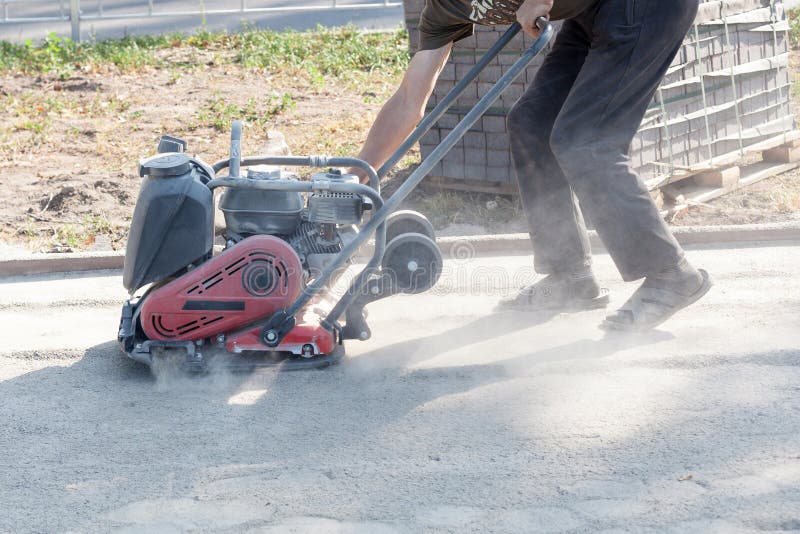 Builder Worker at Sand Ground Compaction with Vibration Plate Compactor ...
