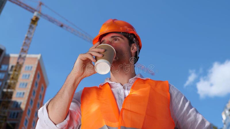 Builder in Working Uniform Drinking Coffee while Standing Construction ...