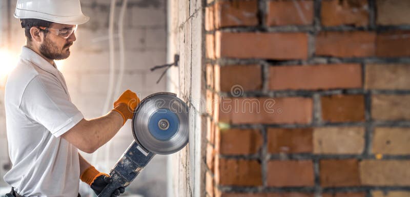 Builder Works with a Angle Grinder To Cut Bricks and Build Interior ...